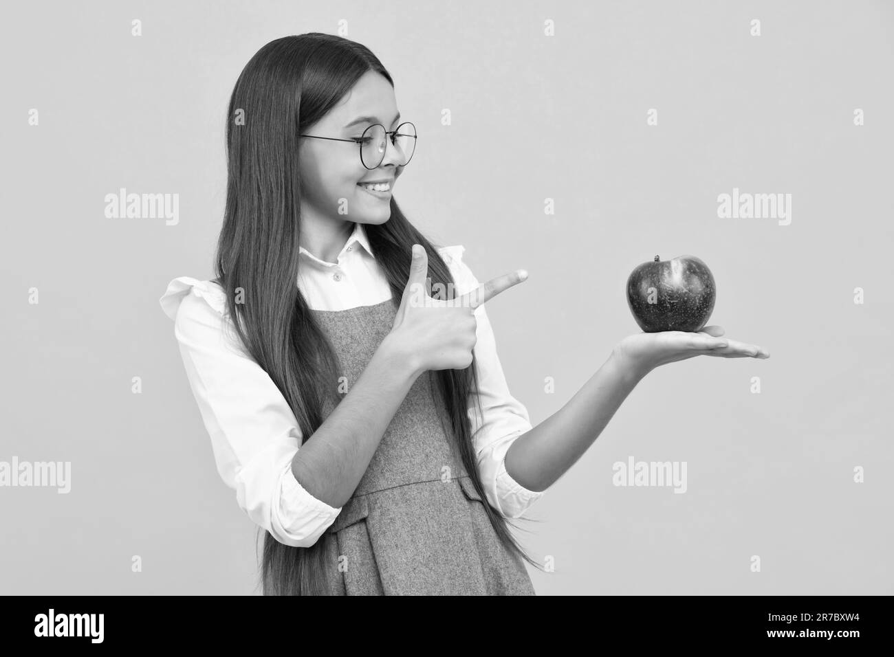 Fresh apple. Teenager girl hold apples on yellow isolated studio ...