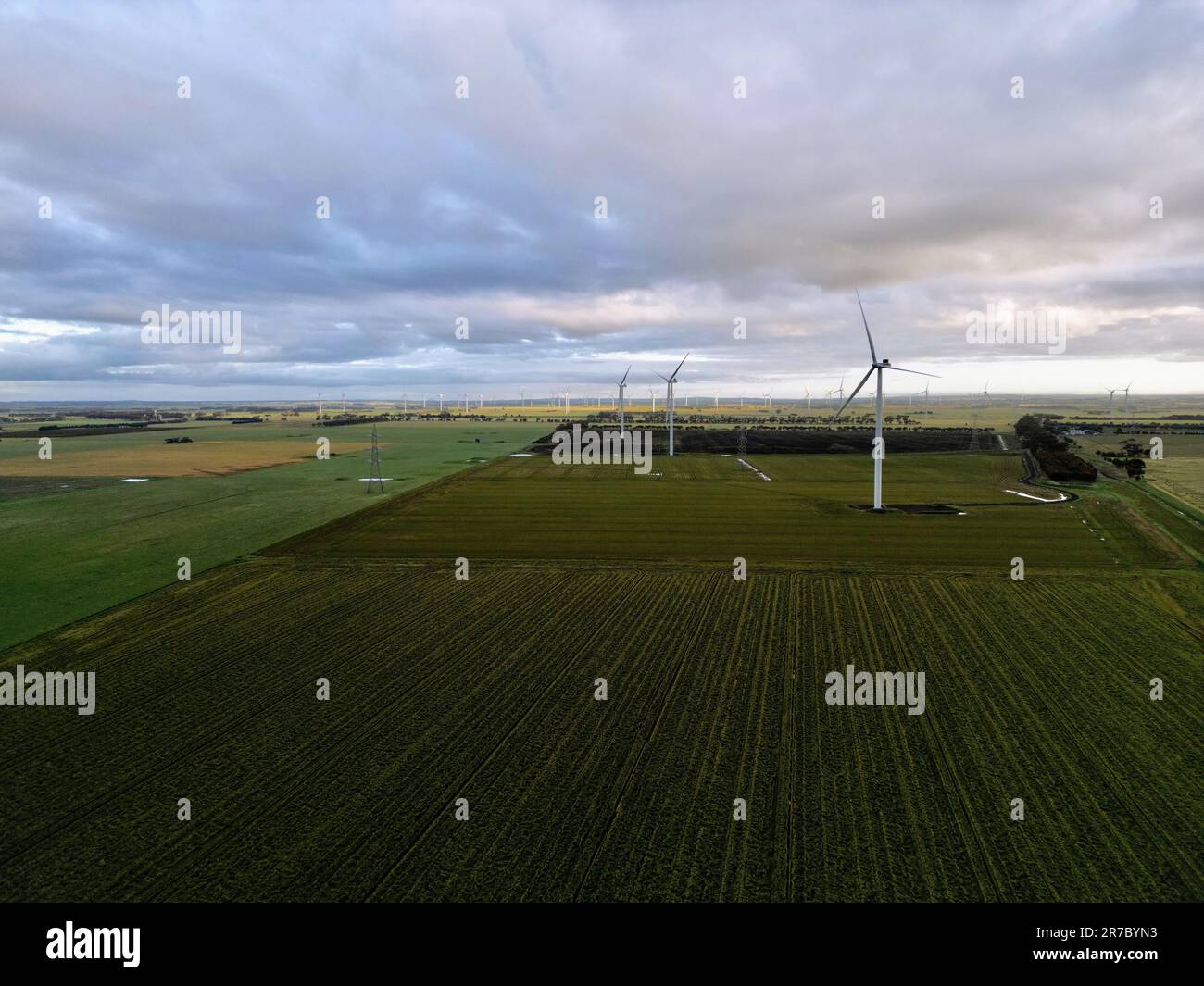 An aerial view of a cluster of wind turbines situated in a vast, empty ...