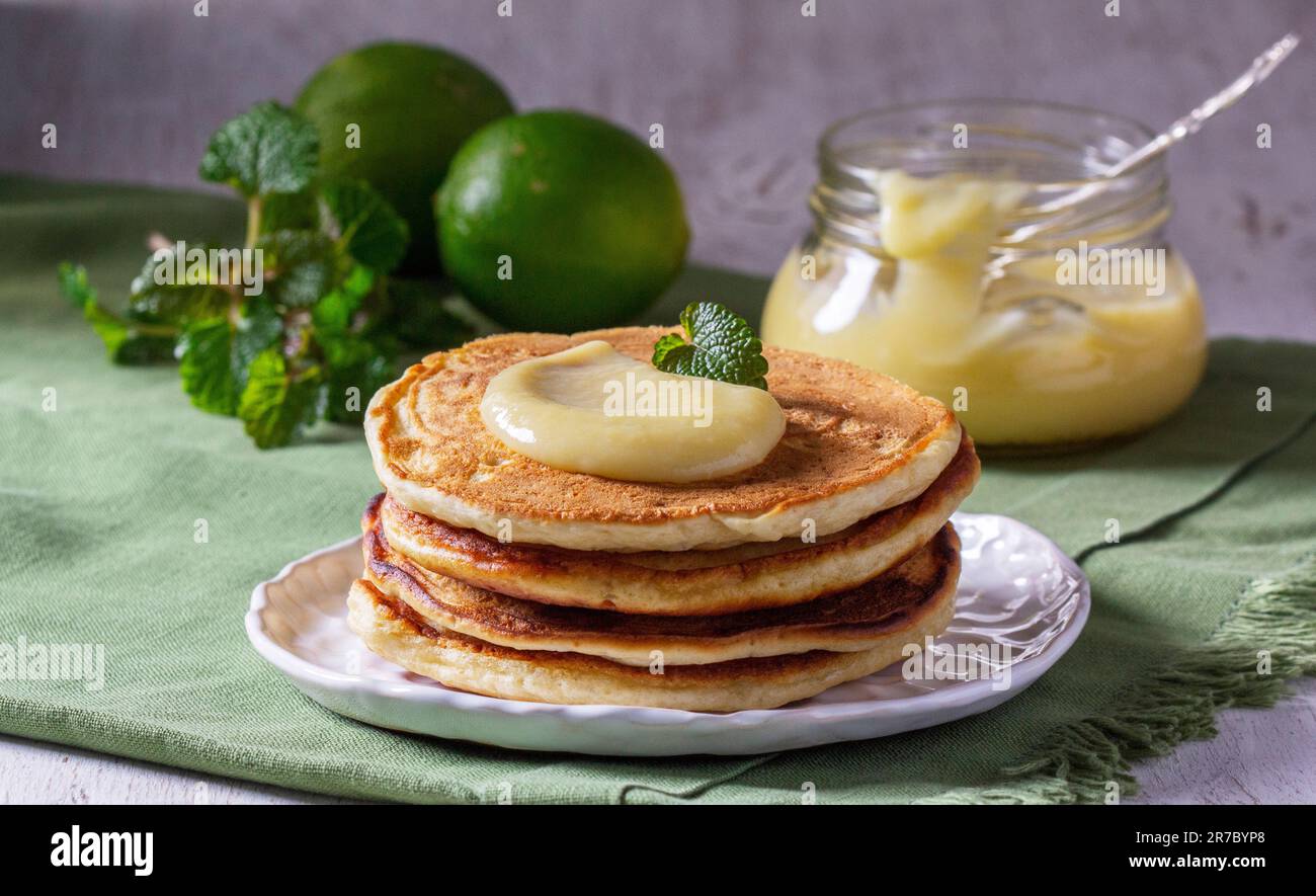 Whole grain flour fritters served with lime curd on a light background ...