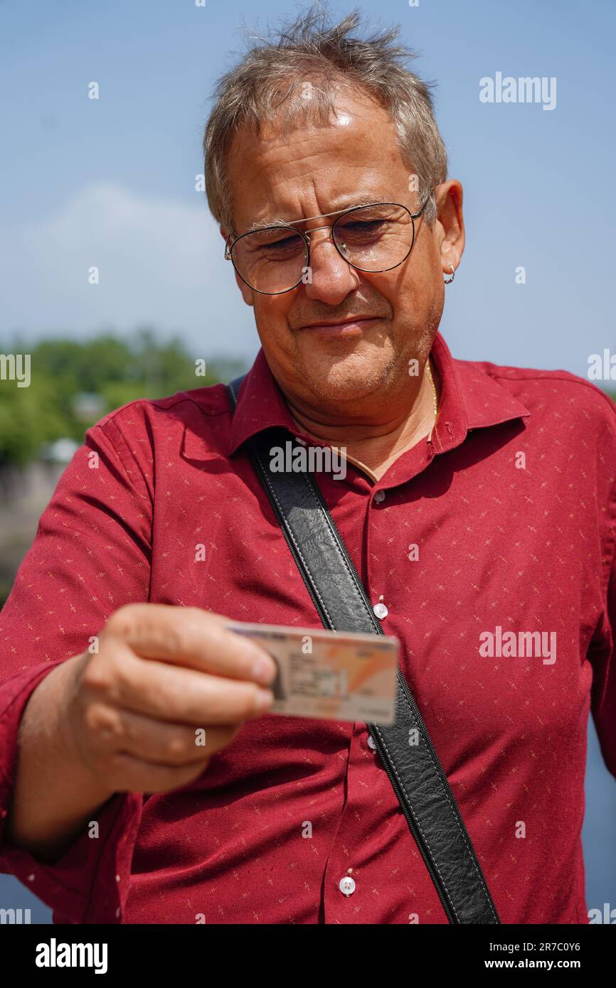 an old man looking at ID (National identity document) outside Stock ...