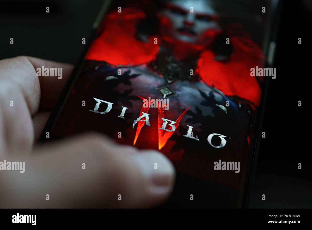 Diablo 4 game logo seen on smartphone hold in a hand. Diablo IV is a ...