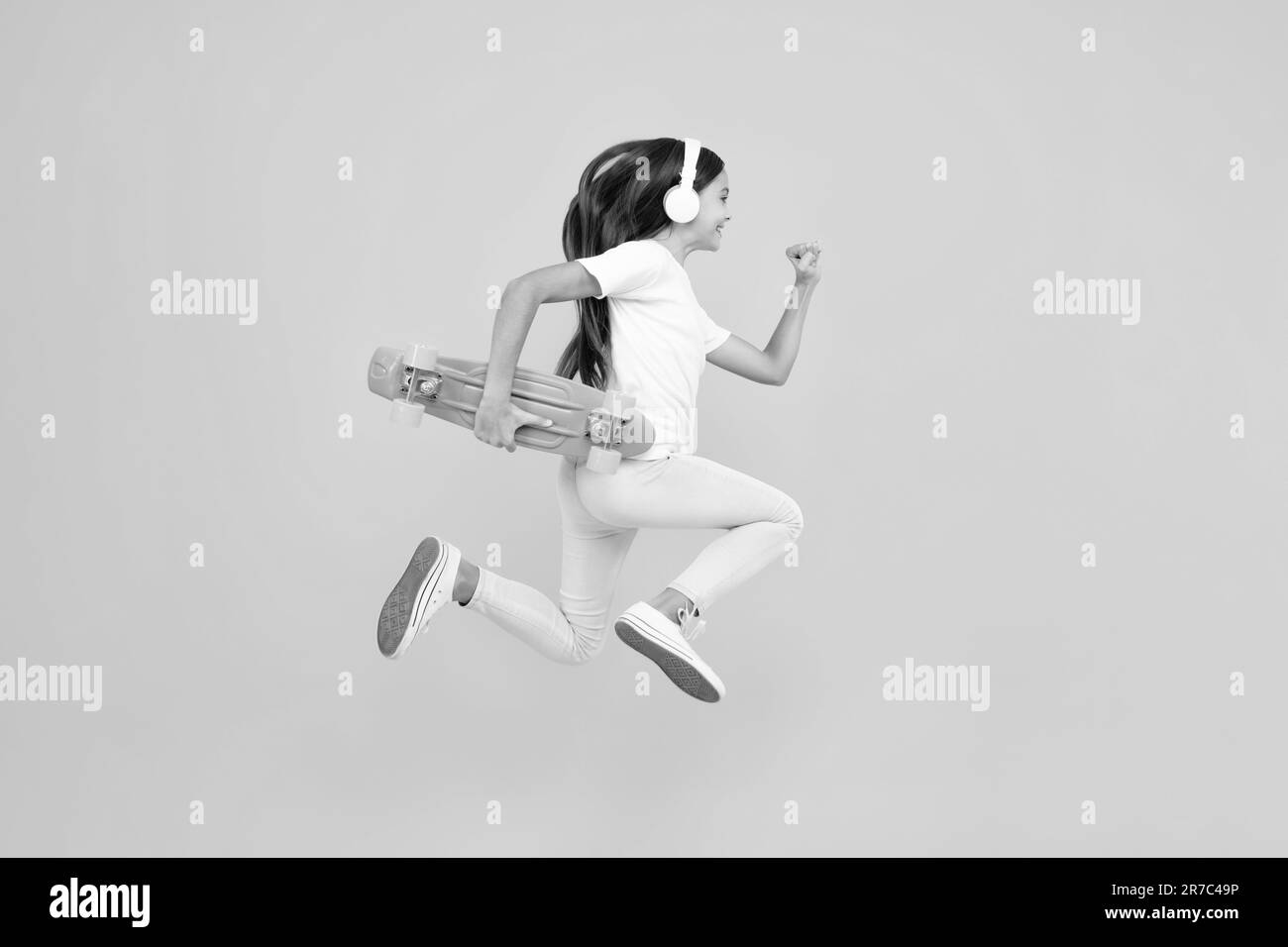 Teen school girl with skateboard on studio isolated background. Spring ...