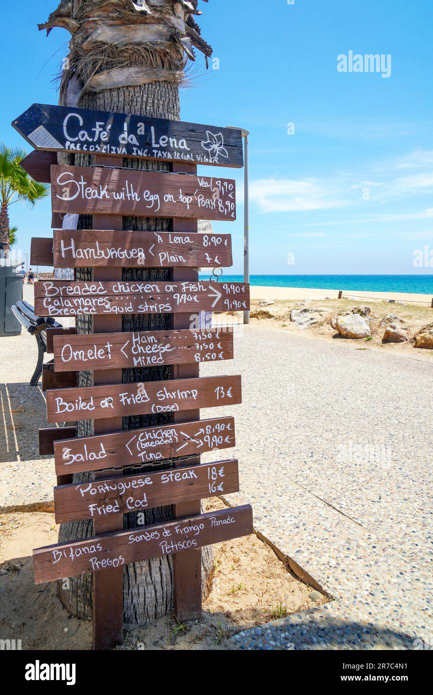 Wooden menu nailed to a tree outside a local beach cafe restaurant on ...