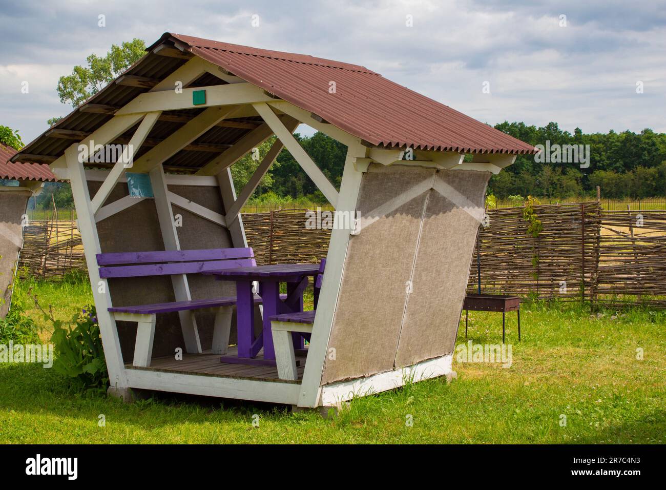 Wooden gazebo in a green forest in summer. Travel and rest. Place to ...