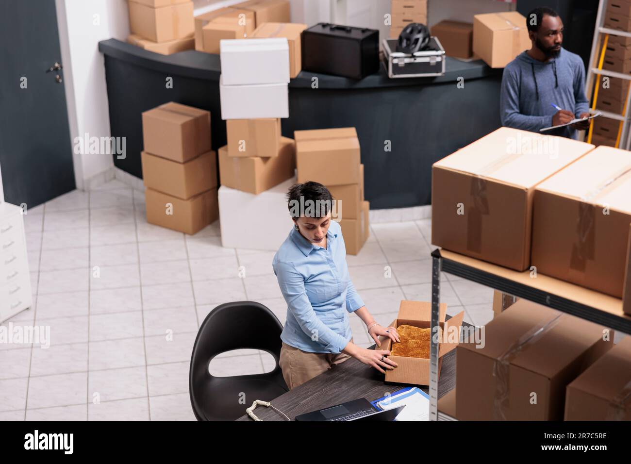 Top view of employee standing at desk in warehouse while preparing ...
