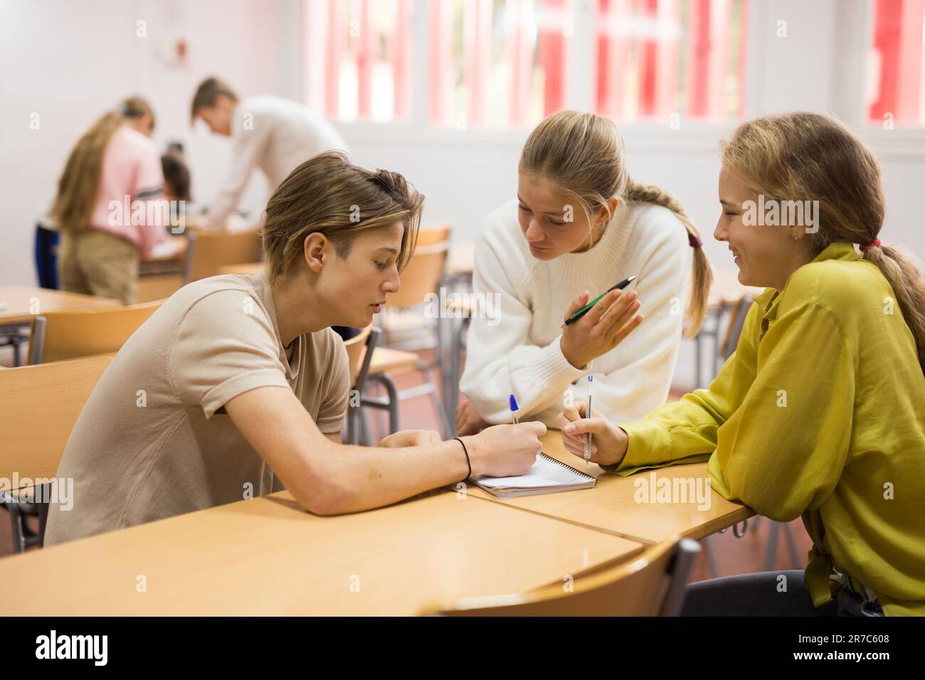 Teens performing group tasks in classroom Stock Photo - Alamy