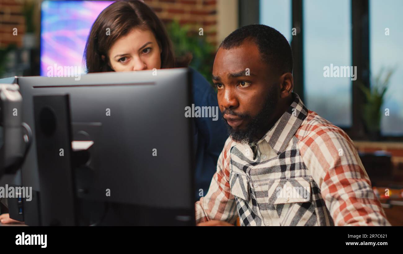 Diverse team of employees working on software development with ...