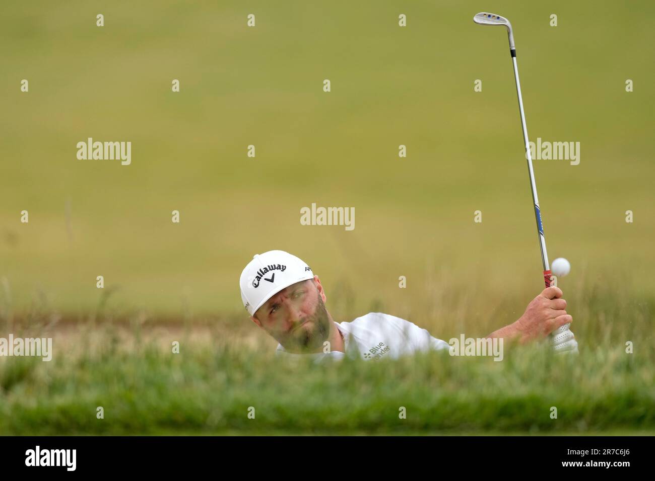Jon Rahm, of Spain, hits from the bunker on the 14th hole during a ...