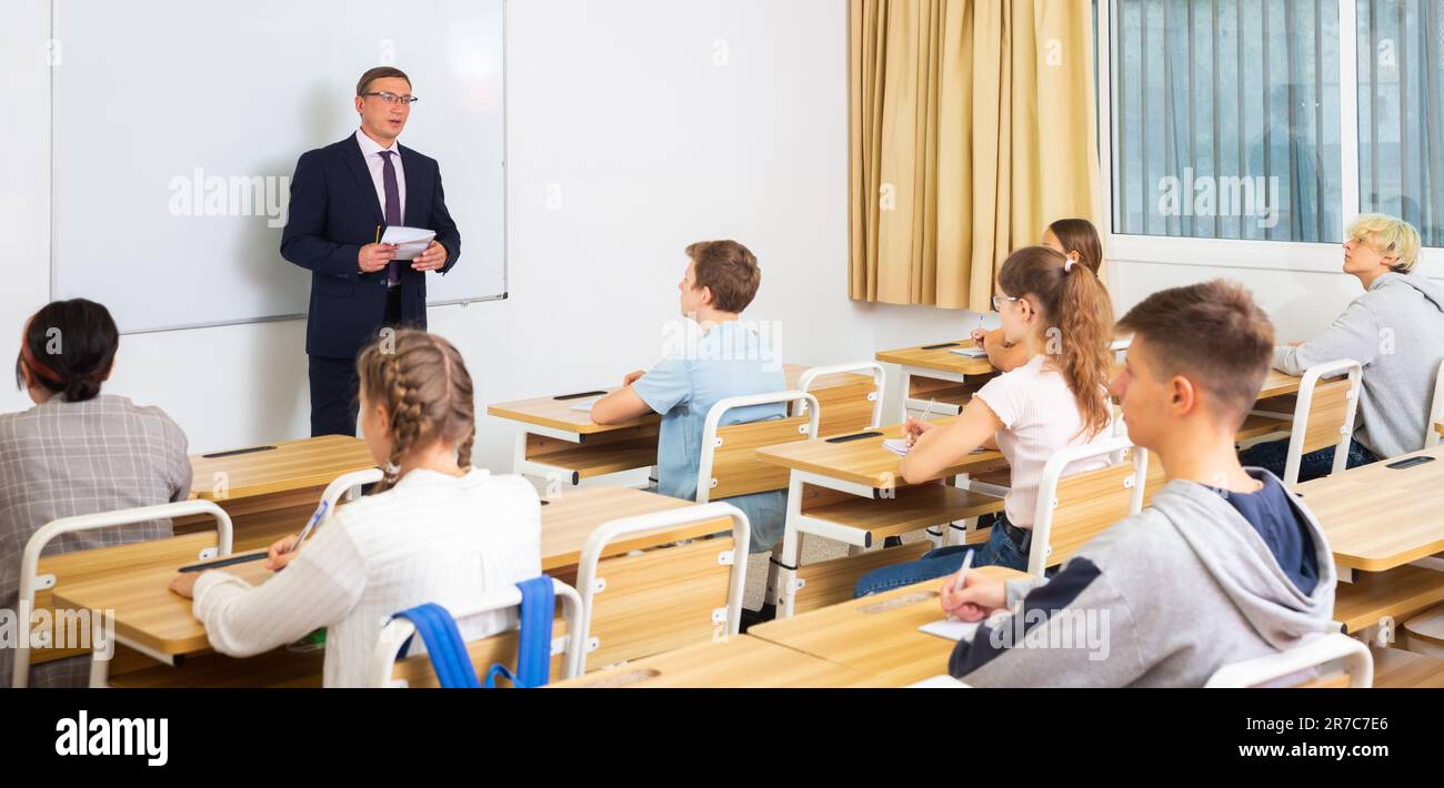 Male teacher lecturing to students at classroom Stock Photo - Alamy
