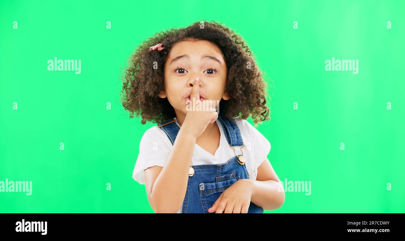 Face, green screen and child with finger on lips for quiet, silence or shush gesture on studio ...