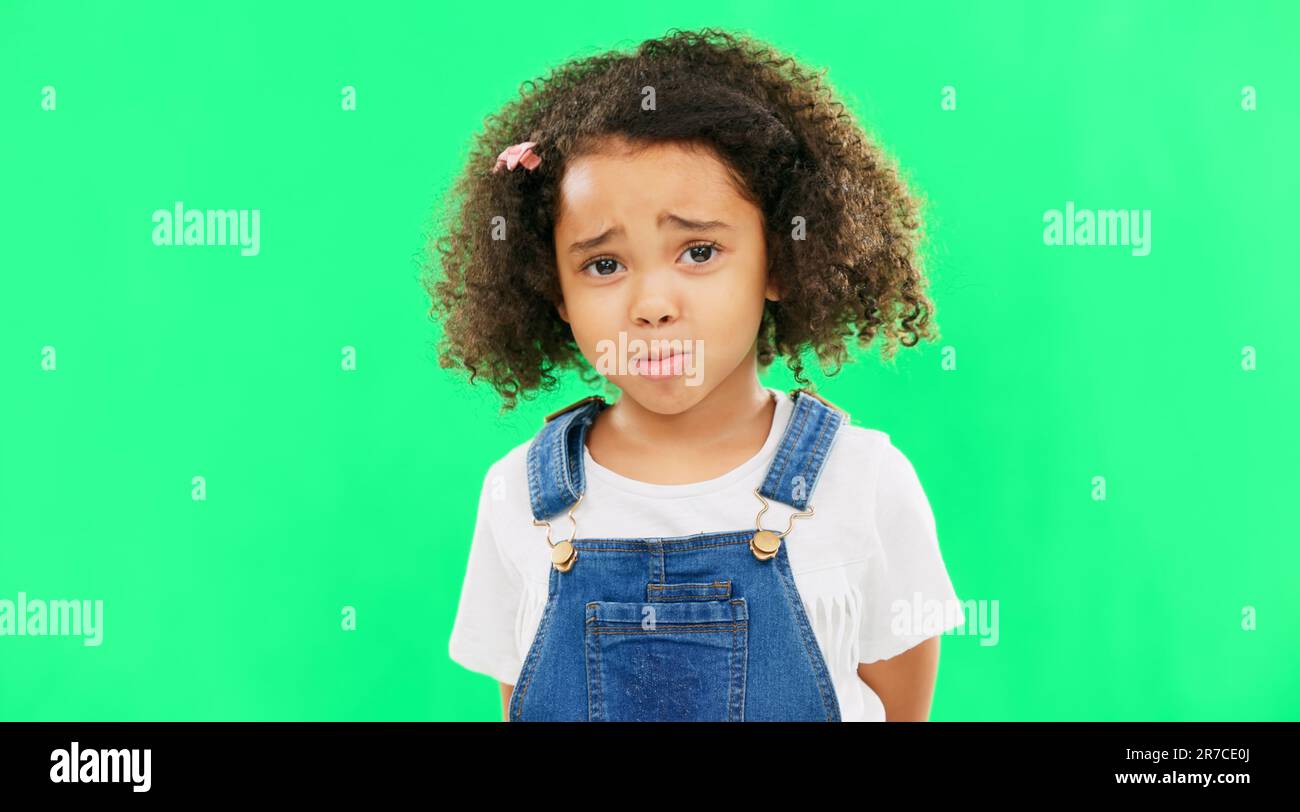 Sad, unhappy and face of a child on a green screen isolated on a studio ...