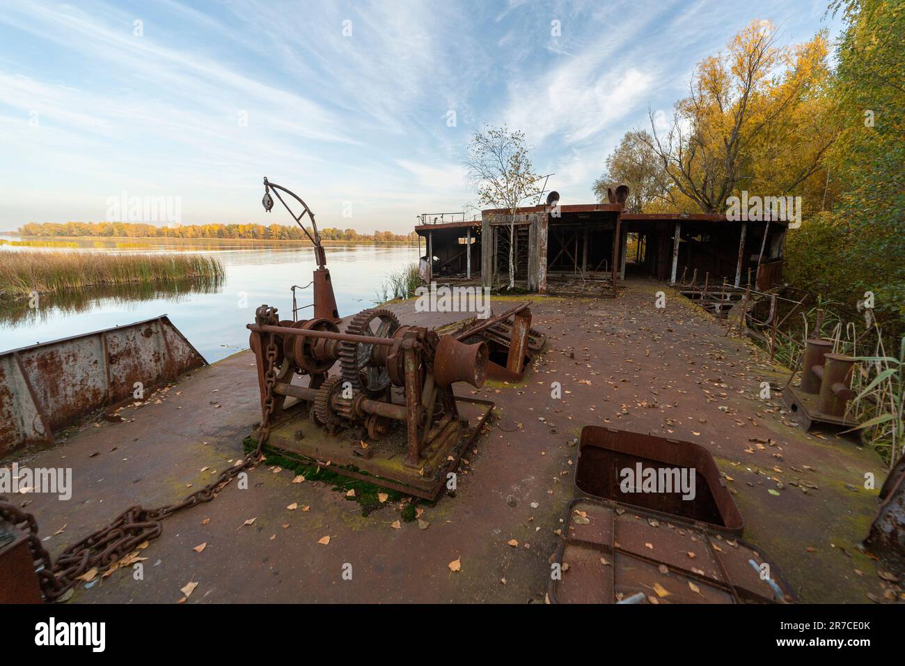 A rustic scene featuring an abandoned truck and boat partially ...