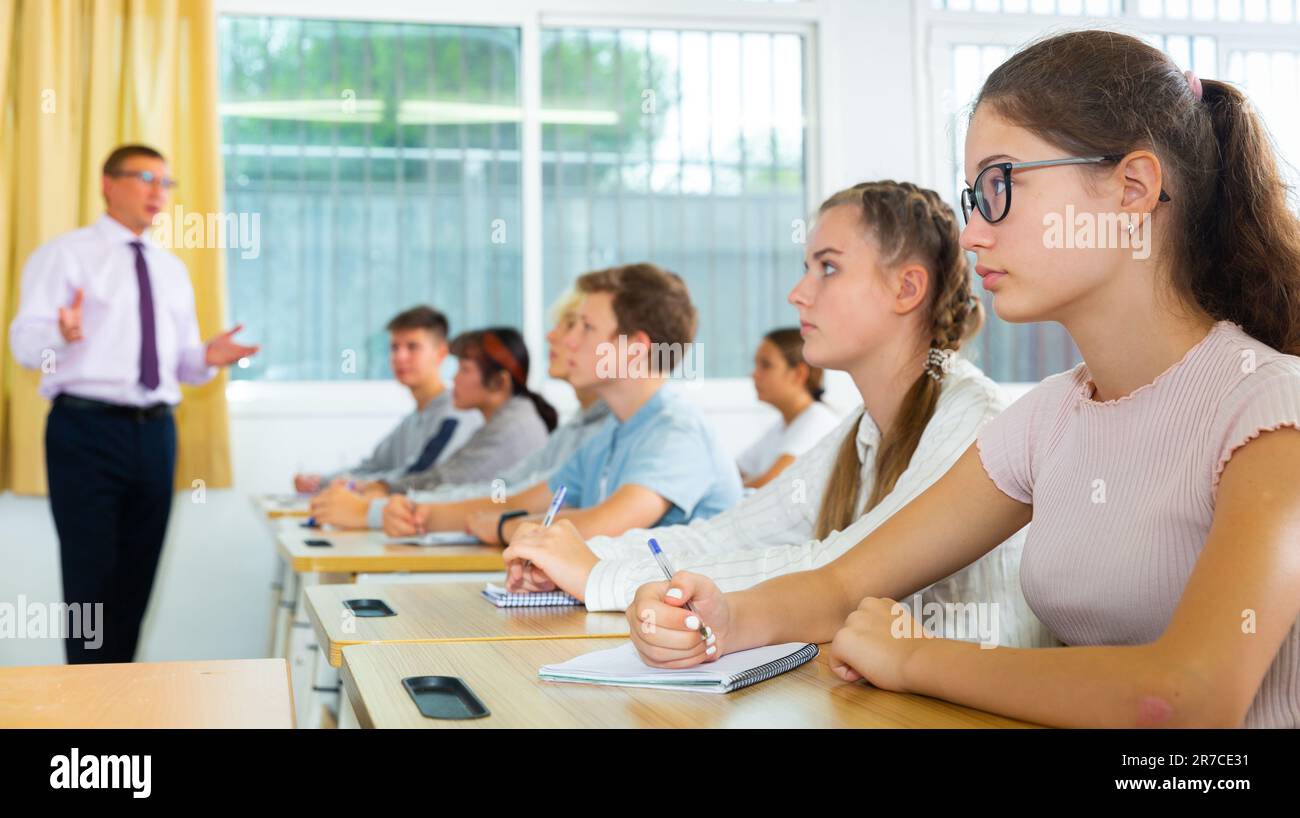 Side view of student group working on lecture in classroom Stock Photo ...