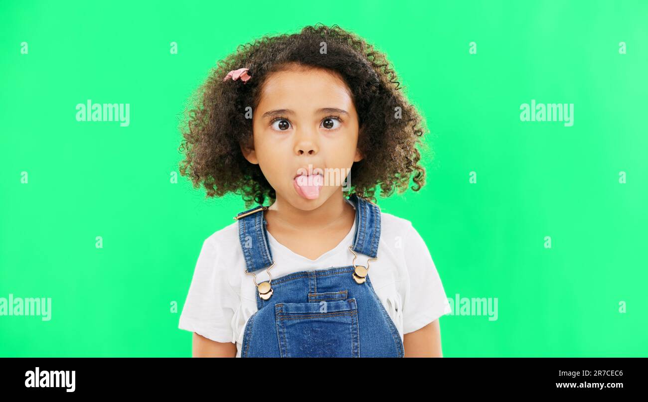Little girl, silly and goofy face on green screen with facial expressions against a studio ...