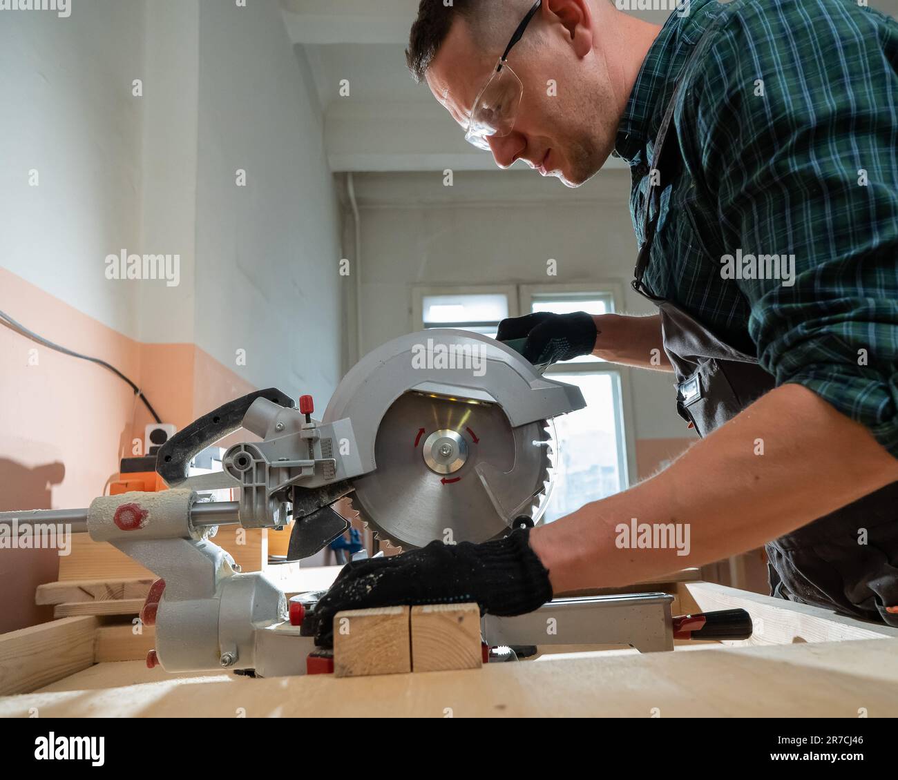 Master cuts the board with a circular saw in the workshop Stock Photo ...
