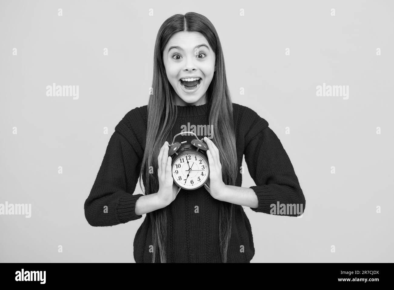 Excited face. Teen student girl hold clock isolated on yellow ...