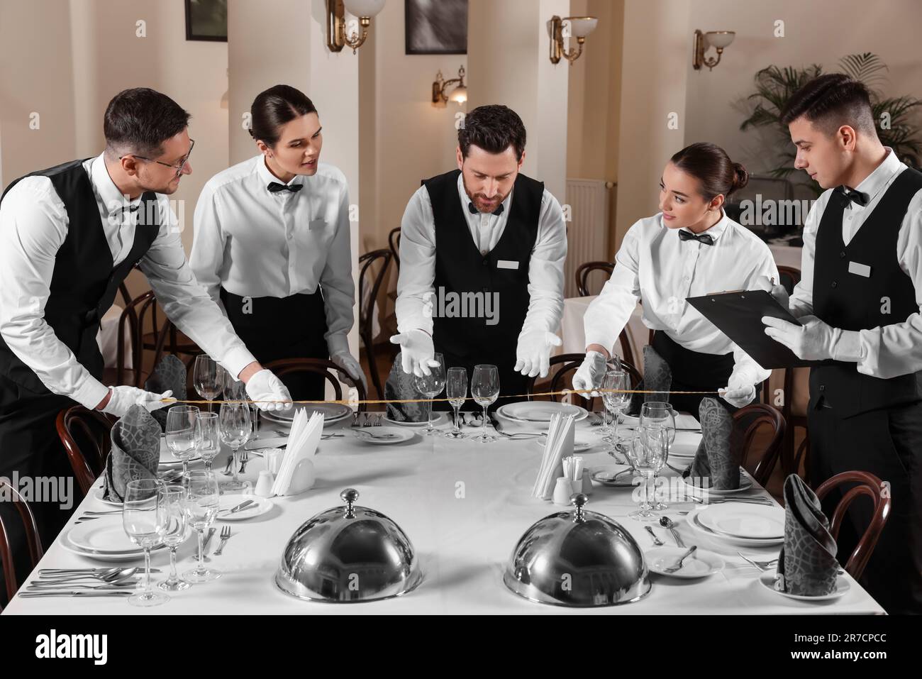 People setting table during professional butler courses in restaurant ...
