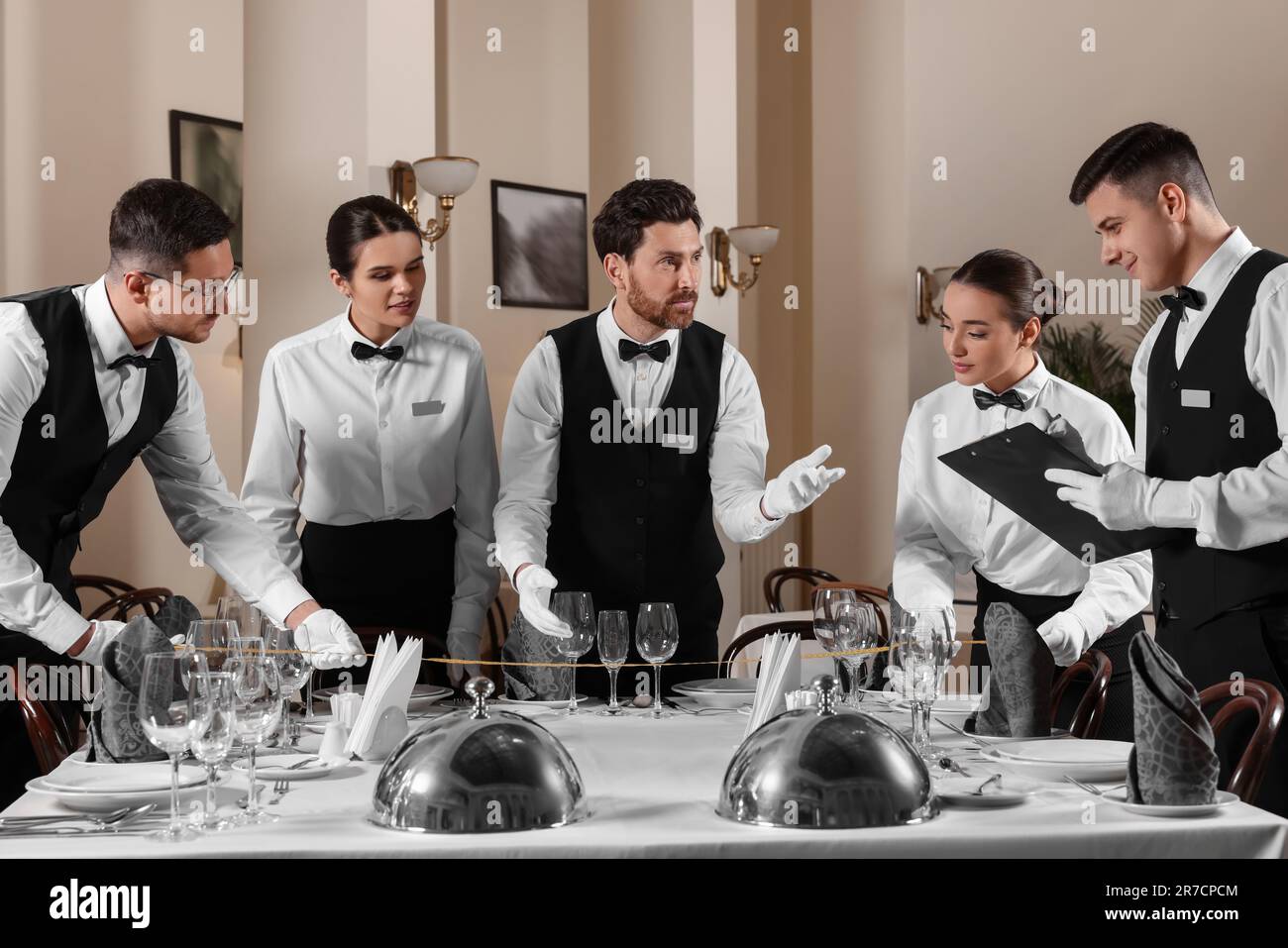 People setting table during professional butler courses in restaurant ...