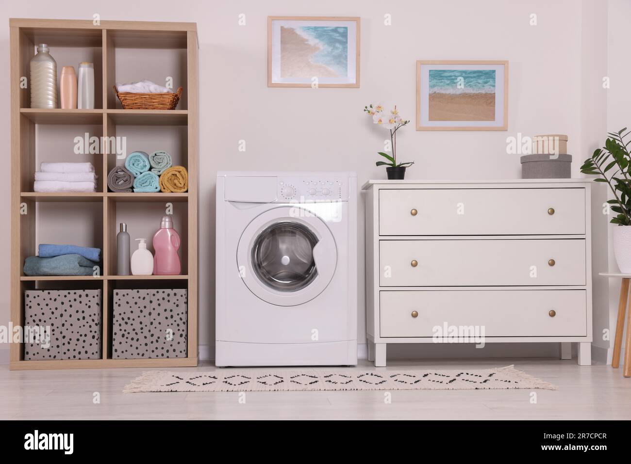 Stylish laundry room with washing machine and chest of drawers ...