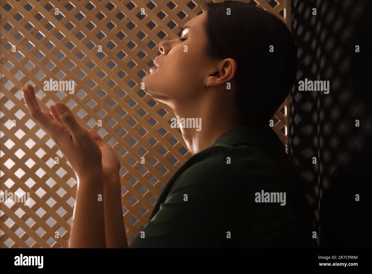Woman praying to God during confession in booth Stock Photo - Alamy