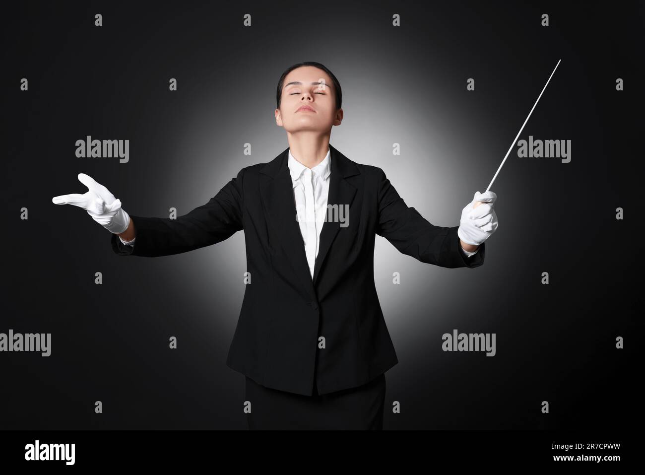 Professional conductor with baton on black background Stock Photo - Alamy