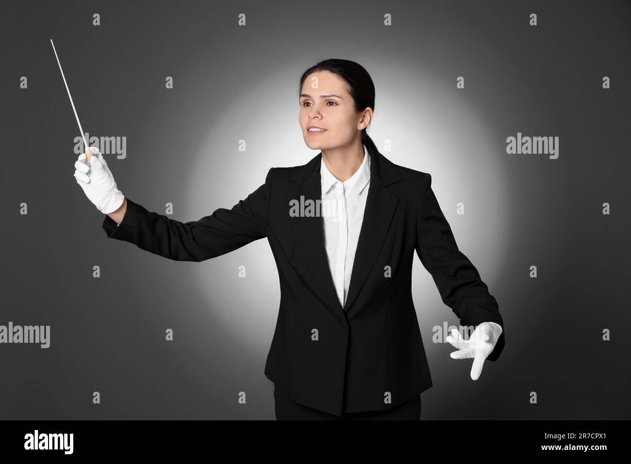 Professional conductor with baton on grey background Stock Photo - Alamy