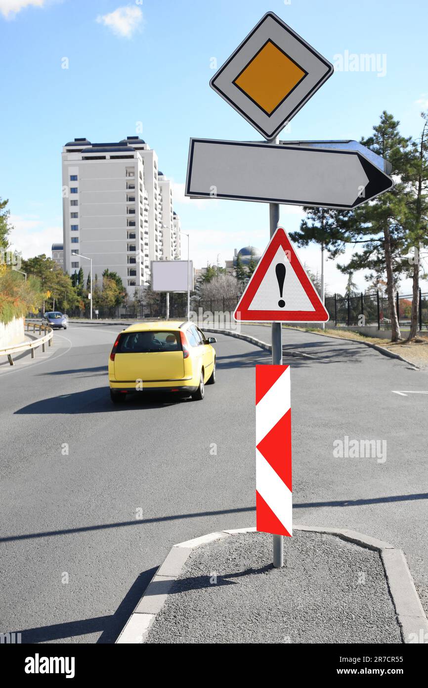 Post with different road signs on city street Stock Photo - Alamy