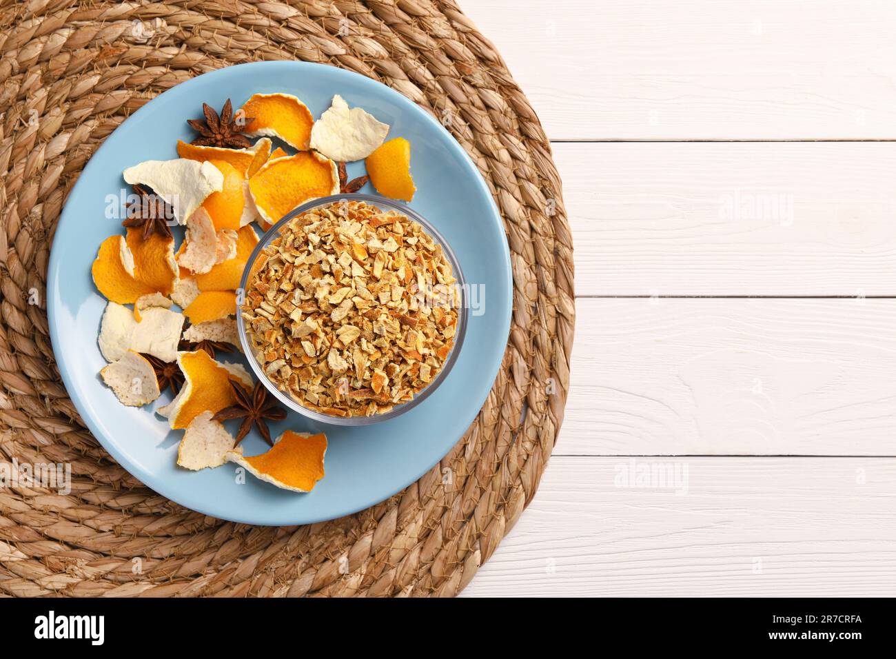Bowl of dried orange zest seasoning, fresh peel and anise on white ...