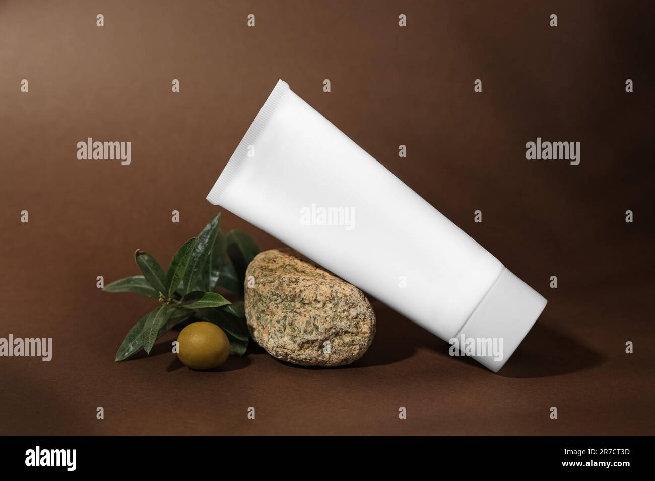 Tube of natural cream, stone and olive on brown background. Cosmetic ...