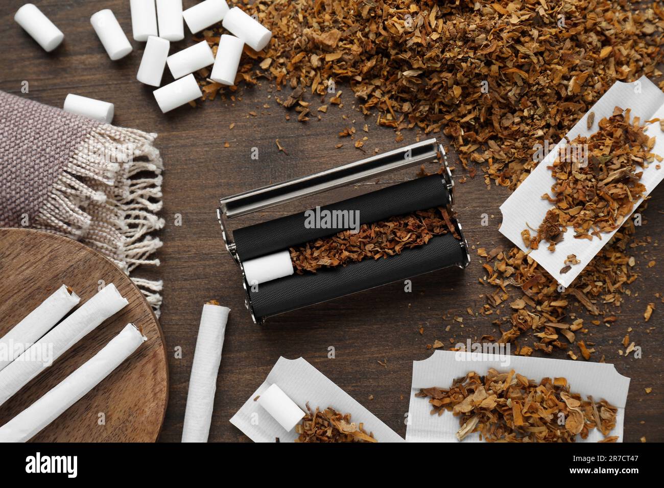 Flat lay composition with roller and tobacco on wooden table. Making ...