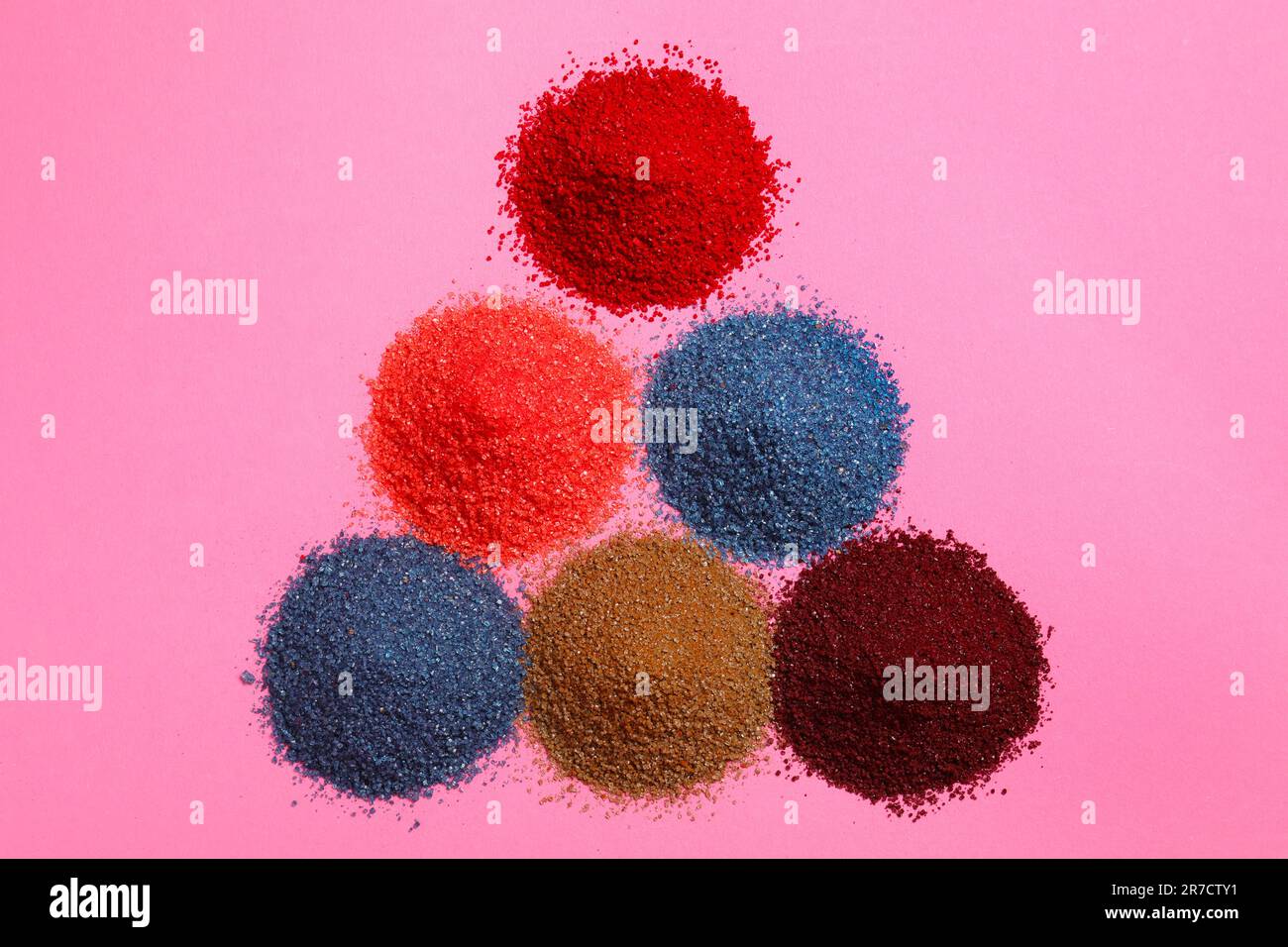 Heaps of different bright food coloring on pink background, flat lay ...