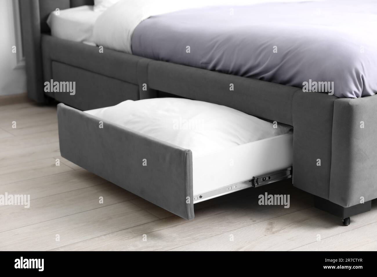 Storage drawer with white pillow under modern bed in room Stock Photo ...