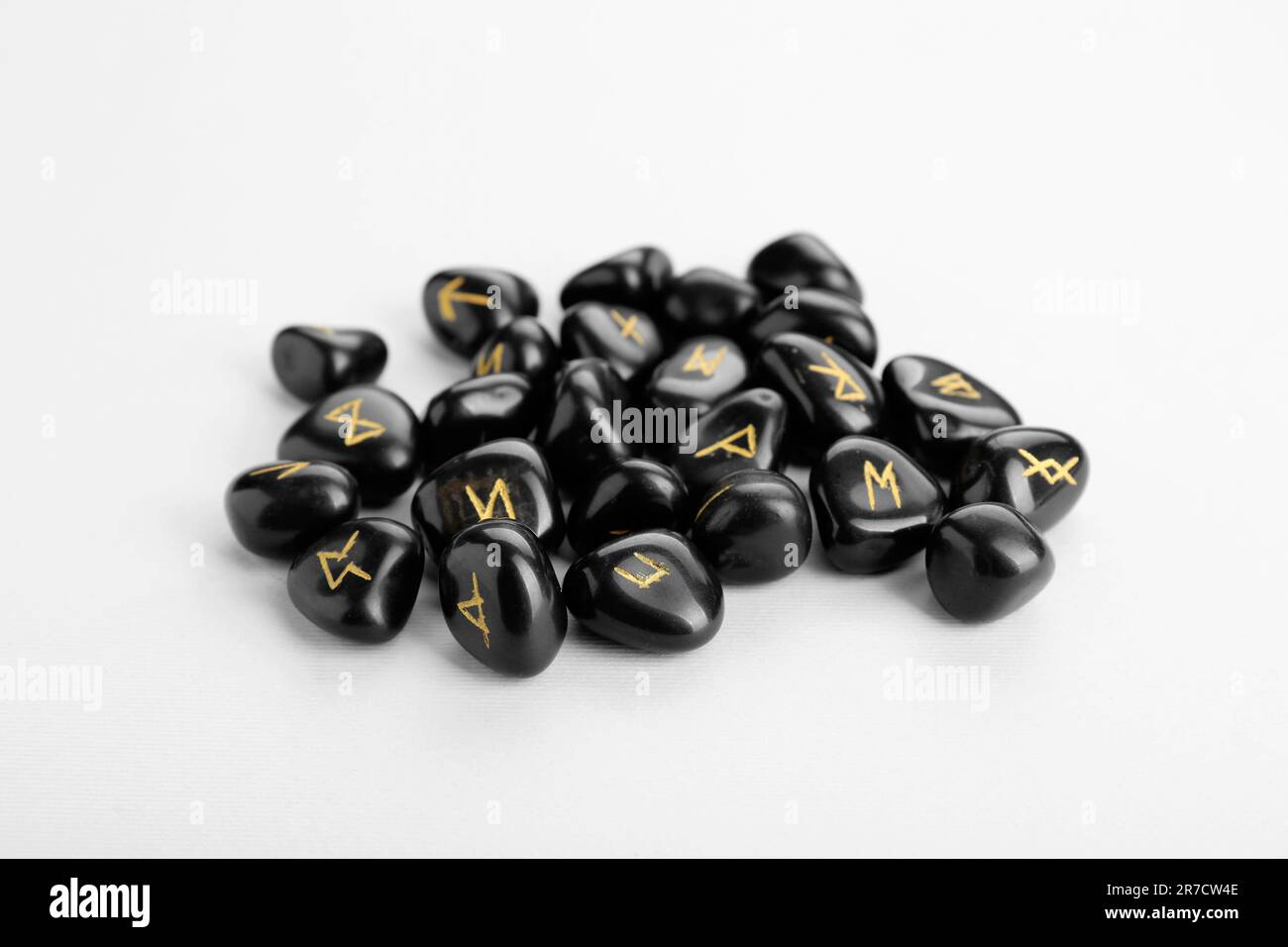 Pile of black rune stones on white background Stock Photo - Alamy