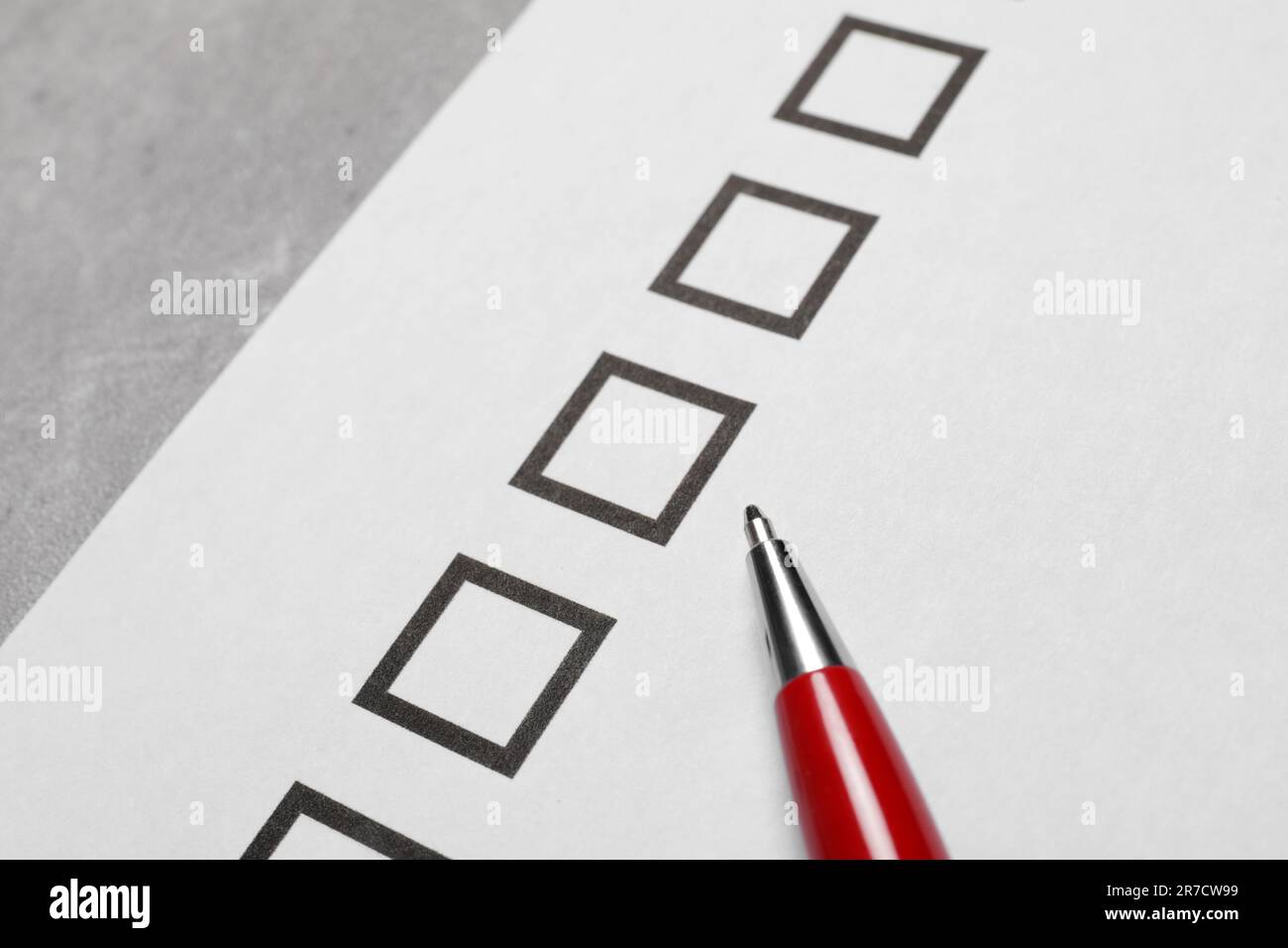 Paper sheet with checkboxes and pen on light grey table, closeup ...