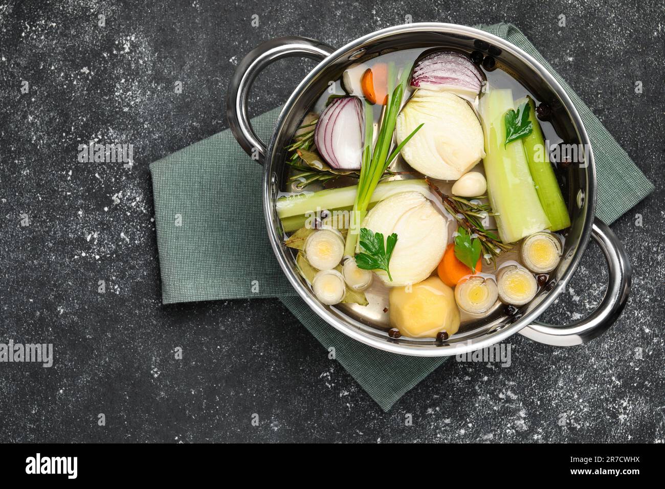 Different ingredients for cooking tasty bouillon in pot on black table ...