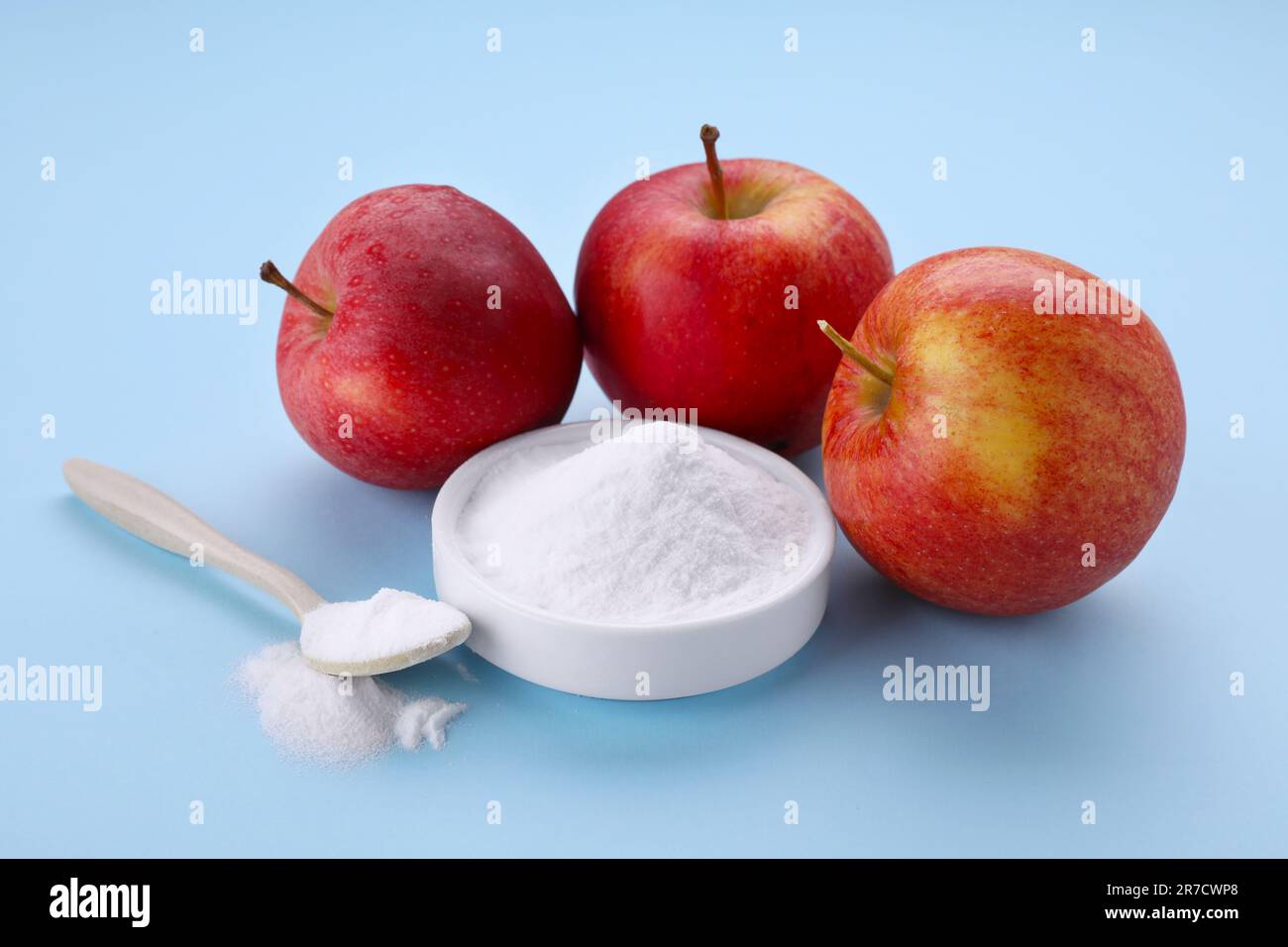 Sweet powdered fructose and fresh apples on light blue background Stock ...