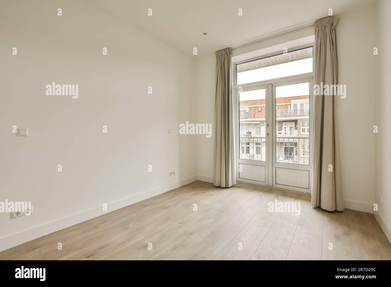 an empty room with wooden floors and white walls, there is a large ...