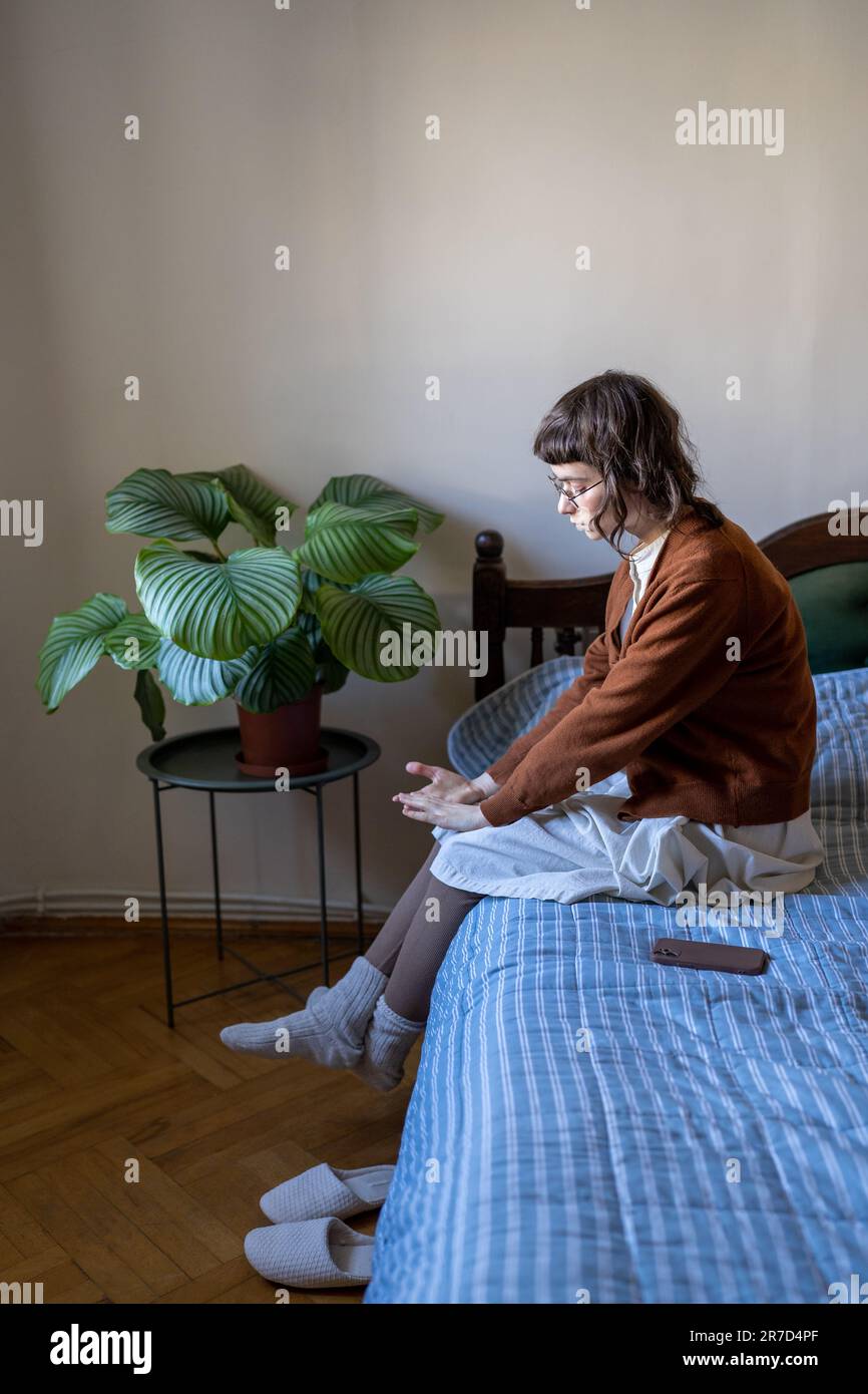 Unhappy depressed introvert teen girl sitting on bed feeling lonely ...