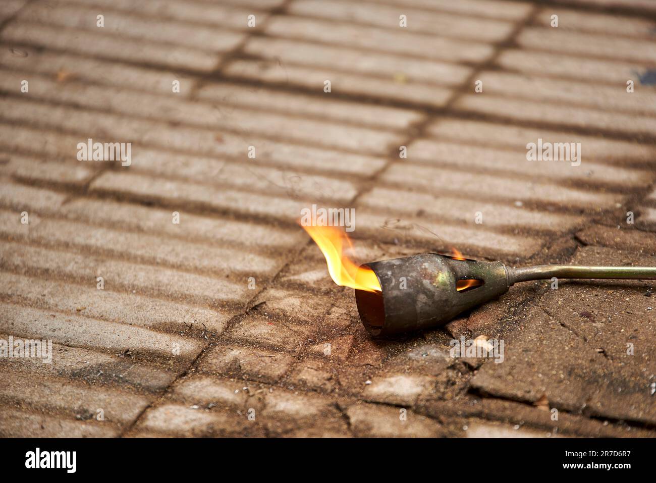 Lit blowtorch, throwing fire leaning on the ground. Composition without ...