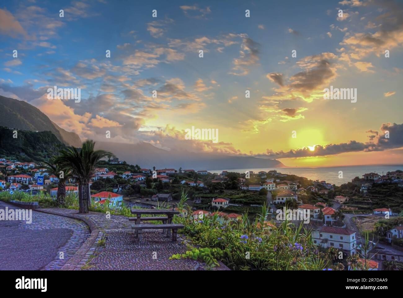 A scenic stone pathway illuminated by the sunset leading to a hill in ...