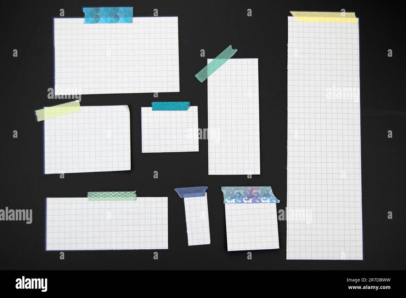 Square lined paper cutouts. Different sizes on black background ...