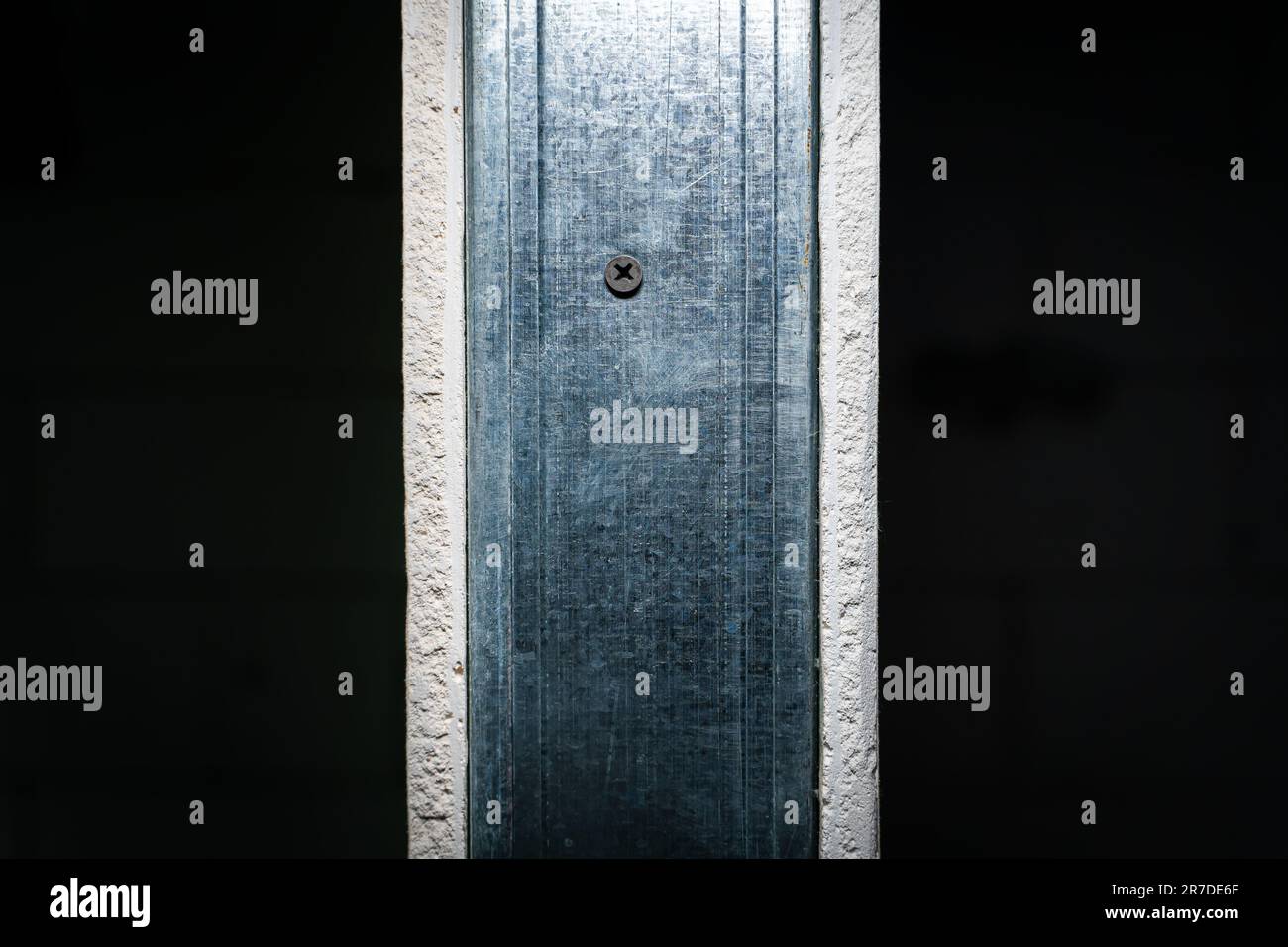 Metal profile sheathed with drywall on both sides close-up on a dark ...