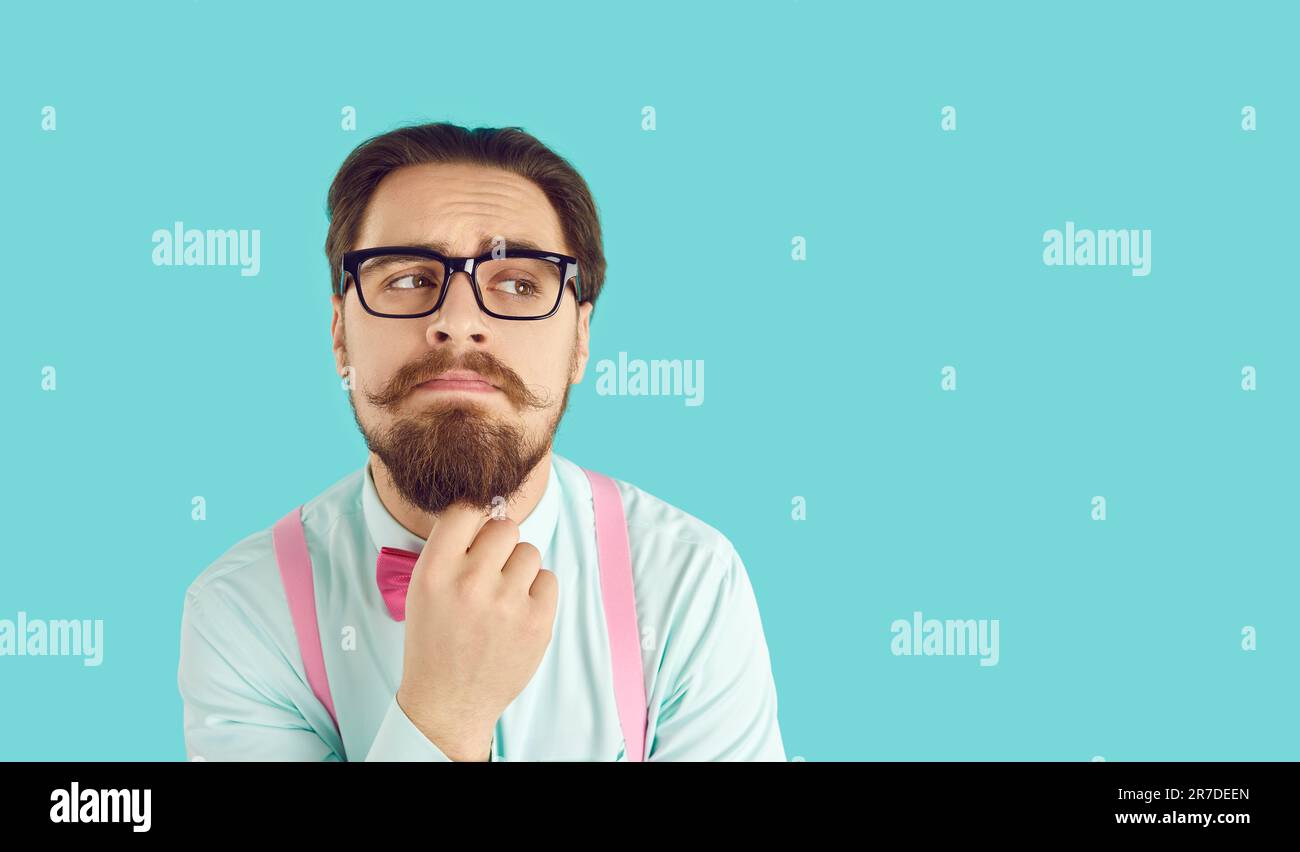 Funny and stylish male nerd thinking or making decisions on light blue ...