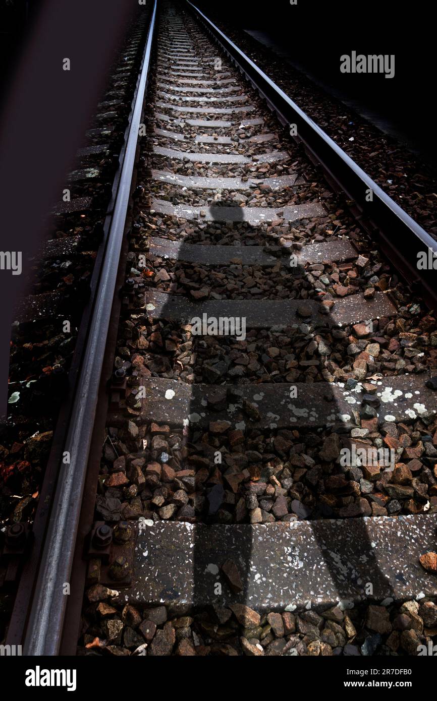 shadow of a mysterious man standing over a railways track Stock Photo ...