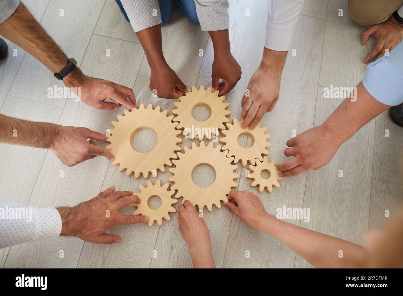 Diverse team of business people connecting cogs to show the concept of ...