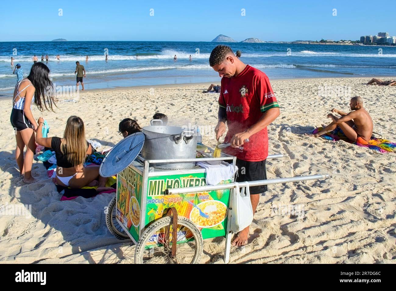 Rio de Janeiro, Brazil - May 25, 2023: A man stands behind a pushcart ...