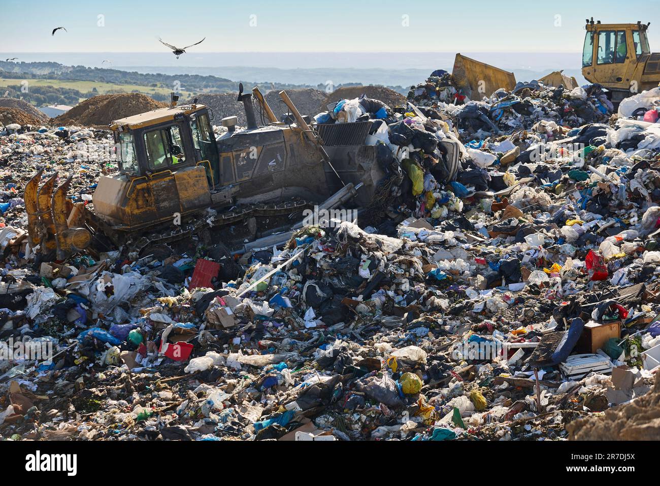 Heavy machinery shredding garbage in an open air landfill. Waste Stock ...