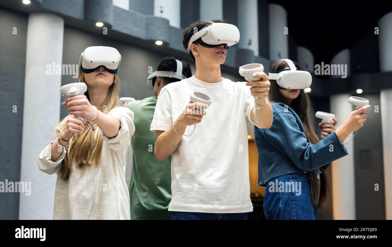 Four teenagers wearing VR equipment and playing on arena Stock Photo ...