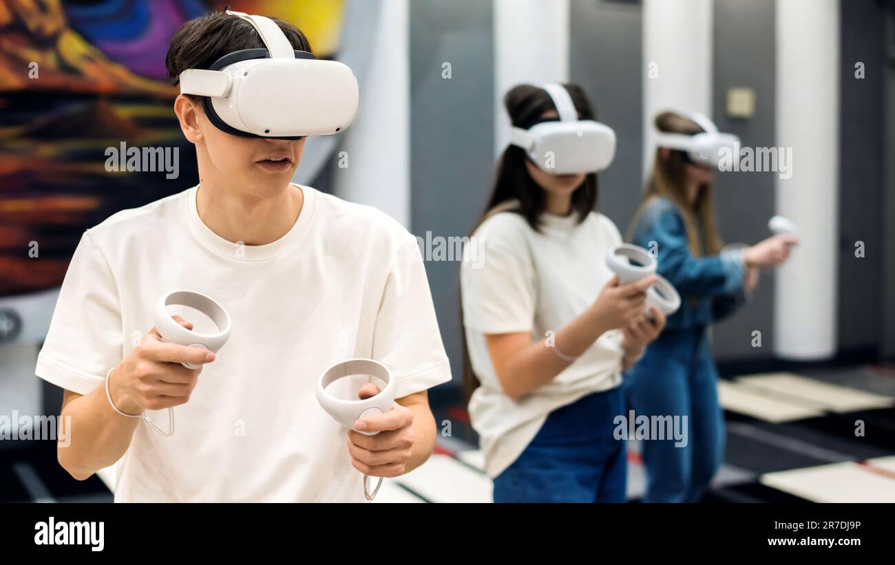 A group of three young friends playing VR games on arena using ...