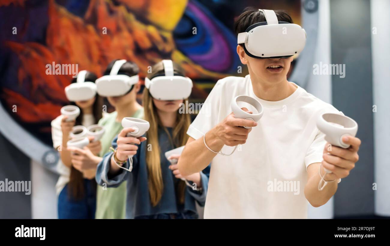 A group of three young friends playing VR games on arena using ...